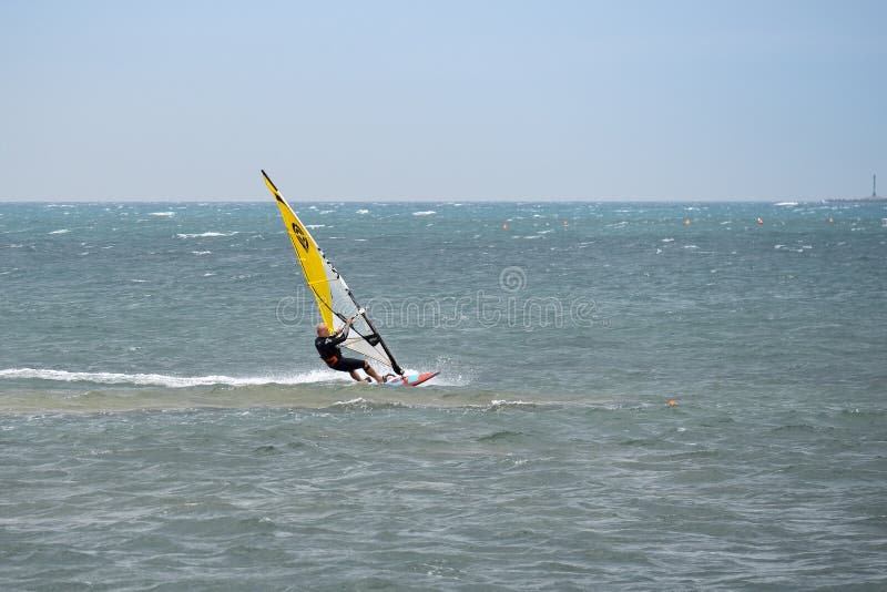 Yellow Windsurf Riding the Waves in a Choppy Sea Stock Photo - Image of ...