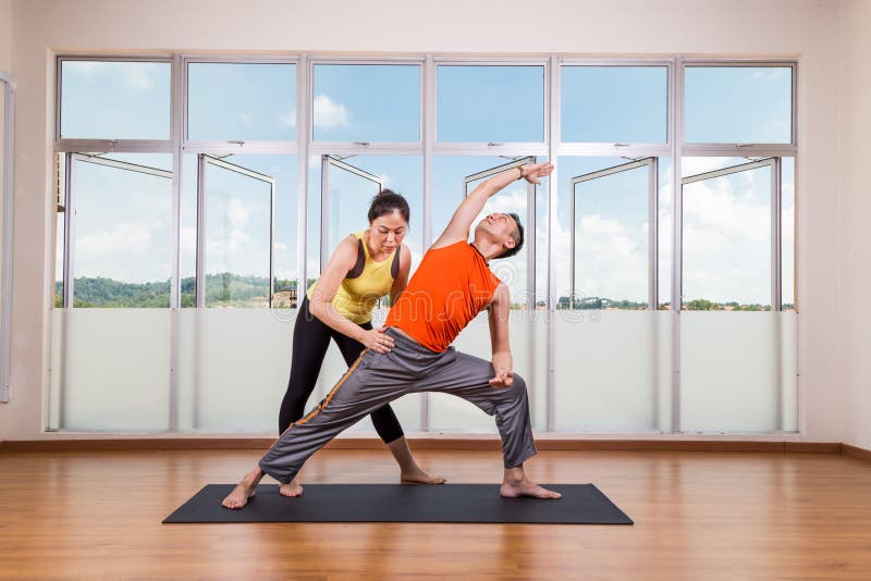 Yoga Instructor Guiding Student Perform Extended Side Angle Pose Stock ...
