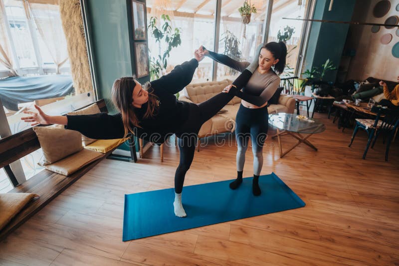 Yoga Lesson with an Instructor Assisting in Improving Balance and ...