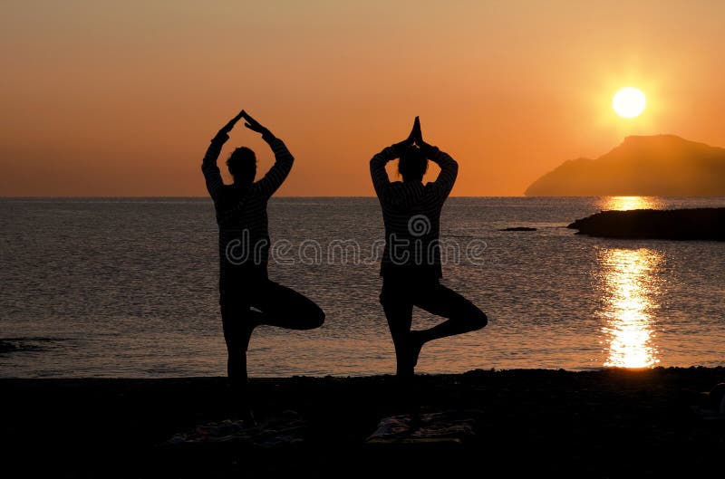 Young Couple Practicing Yoga on Beach at Sunset Stock Photo - Image of ...