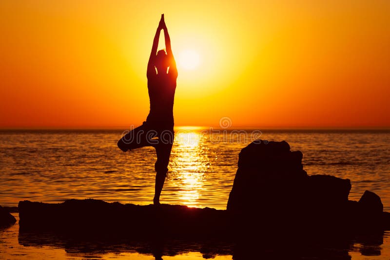 Young Beautiful Slim Woman Practices Yoga on the Beach at Sunset Stock ...