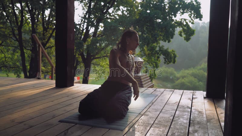 Yogi Performs Exercise Twisting Back with Your Knees Bent. Stock ...