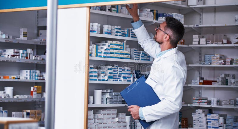 You Need it, Hes Got it. a Mature Pharmacist Doing Inventory in a ...