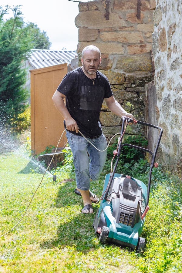 Yound Man Mowing the lawn stock photo. Image of male - 78788796