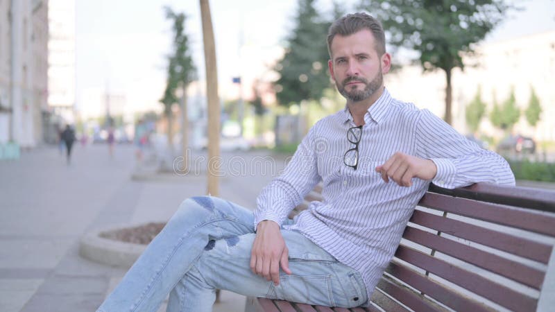 Young Adult Man Looking at Camera while Sitting on Bench Stock Image ...