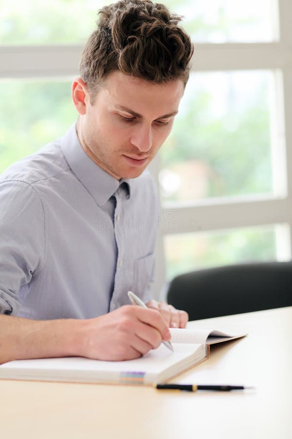 Young Adult Man Writing Note Stock Photo - Image of light, document ...
