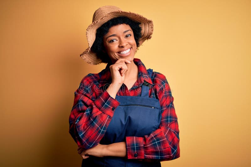 Young African American Afro Farmer Woman With Curly Hair Wearing Apron