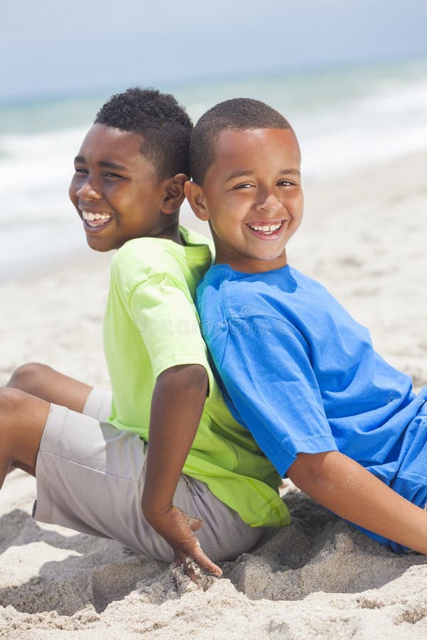 Young African American Boys Sitting on Beach Stock Photo - Image of ...