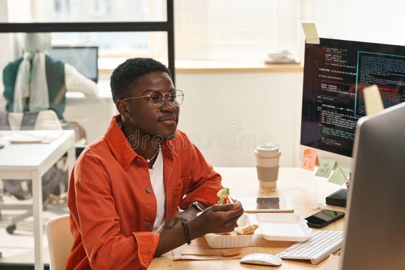 Young African American it Engineer Looking at Computer Screen by Lunch ...