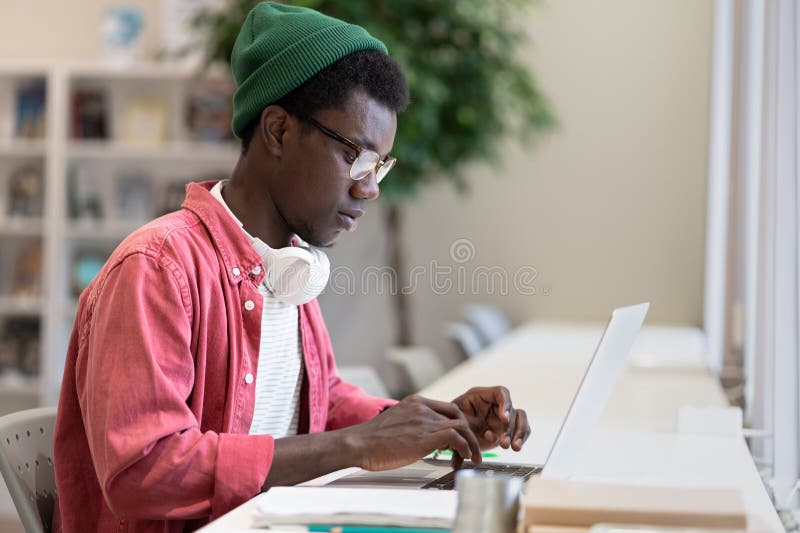 Young African American Man Freelancer Working on Laptop Using Public ...
