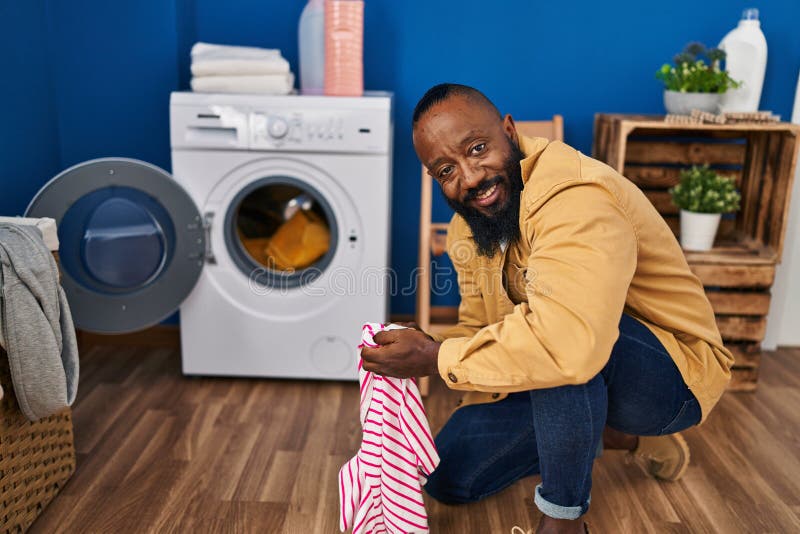 Young African American Man Looking Clothes Label at Laundry Room Stock ...
