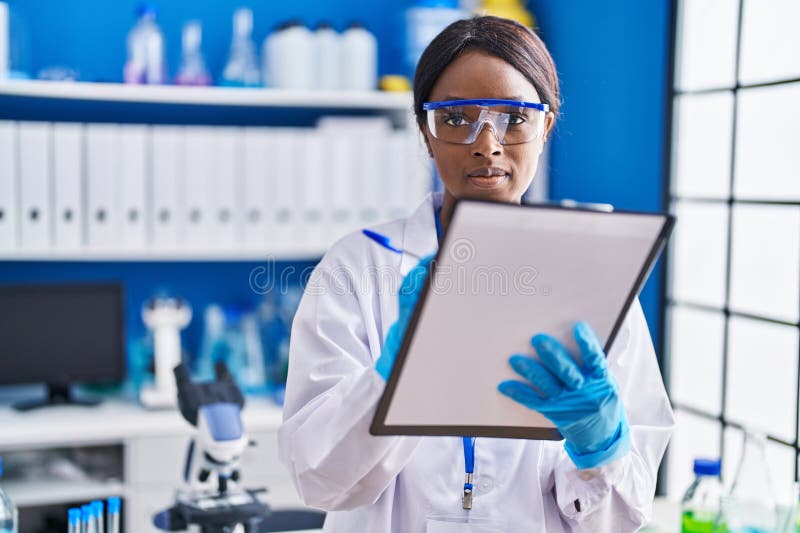 Young African American Woman Scientist Writing on Document at ...