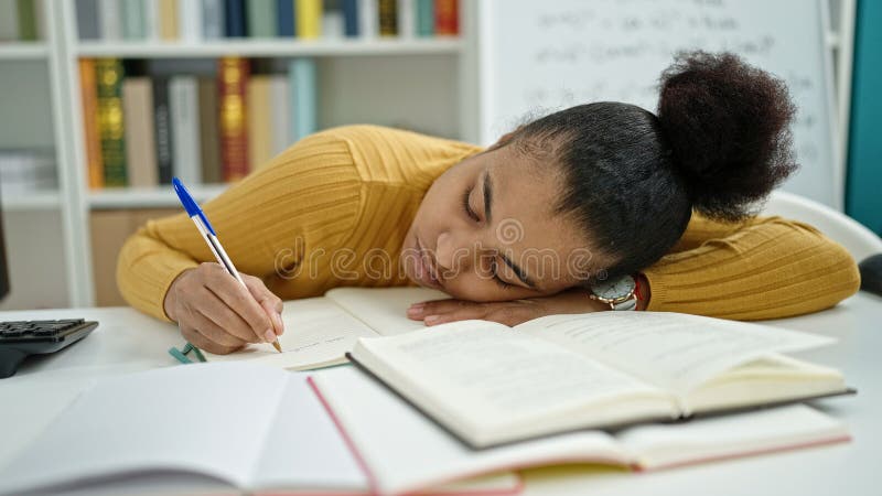 Young African American Woman Student Taking Notes Tired at the Library ...