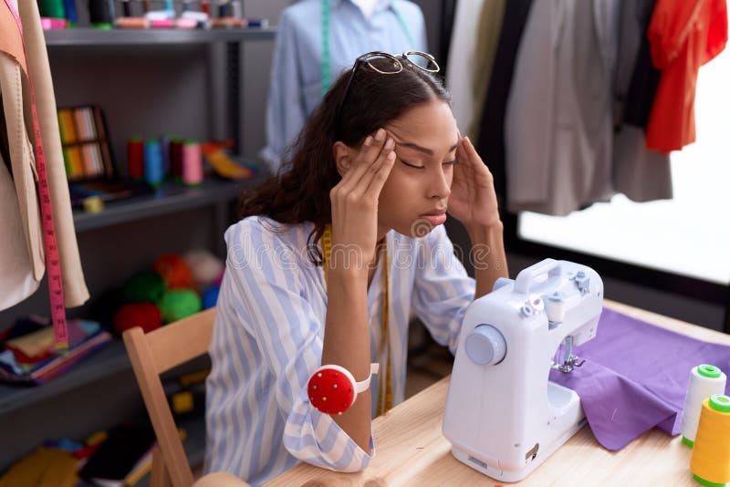 Young African American Woman Tailor Stressed Using Sewing Machine At