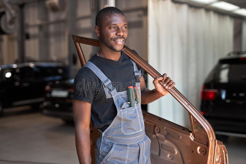 Young African Auto Mechanic at Work with Separate Part of the Machine ...