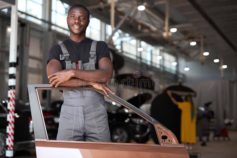 Young African Auto Mechanic at Work with Separate Part of the Machine ...