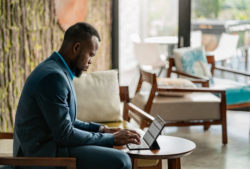 Young African Businessman Using a Tablet in an Office Lobby Stock Photo ...