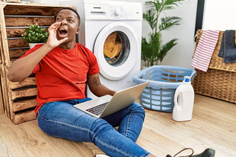 Young African Man Doing Laundry and Using Computer Shouting and ...