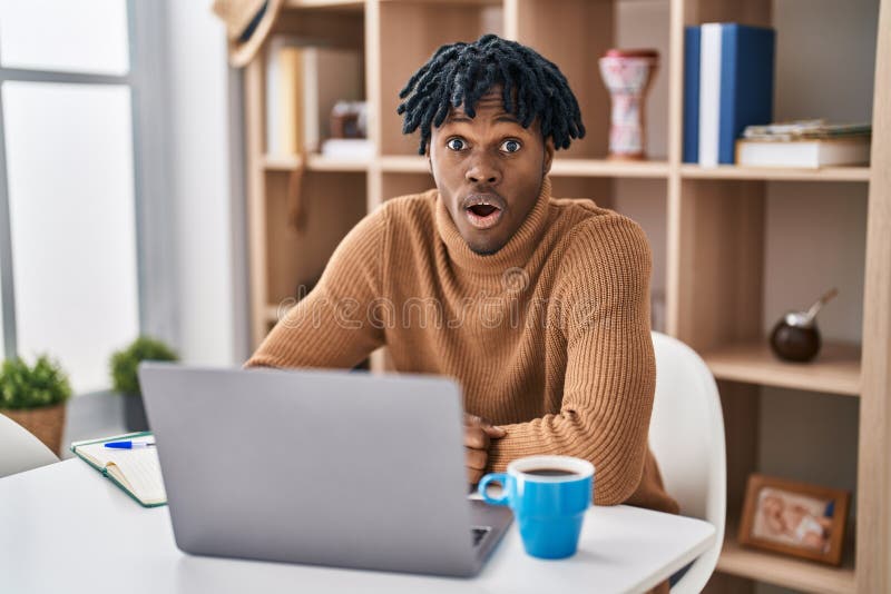 Young African Man with Dreadlocks Working Using Computer Laptop Afraid ...