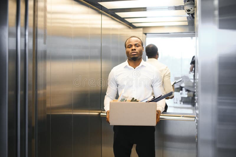 A Young African Man Fired from Work is Standing in the Elevator with a ...