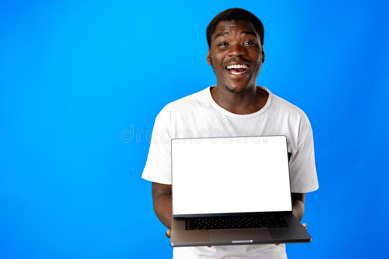 Young African Man Holding Laptop Against Blue Background Stock Image ...
