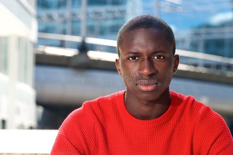 Young African Man Sitting Outdoors Looking Serious Stock Image - Image ...
