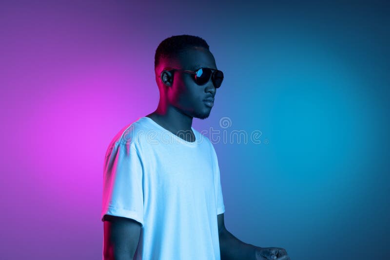 Young African Man In Sunglasses Posing In Neon Light On Gradient