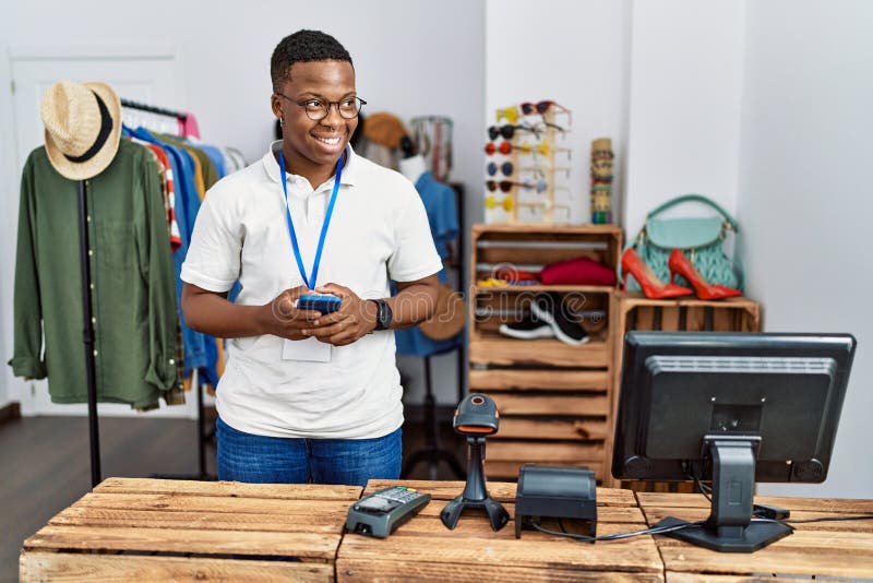 Young African Man Working As Shop Assistance Using Smartphone at Retail ...