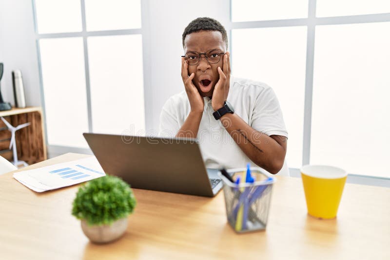 Young African Man Working at the Office Using Computer Laptop Afraid ...