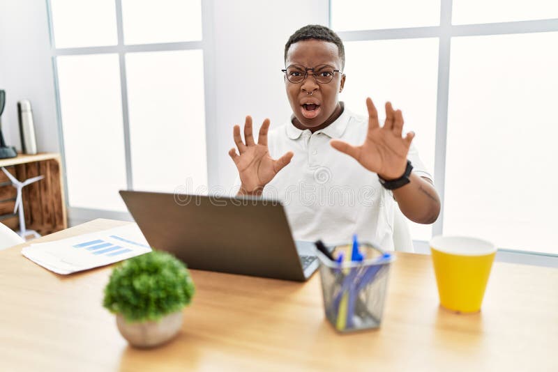 Young African Man Working at the Office Using Computer Laptop Afraid ...