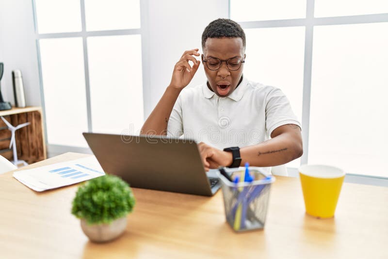 Young African Man Working at the Office Using Computer Laptop Looking ...