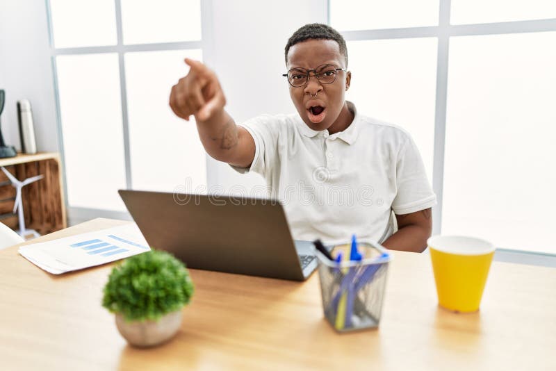 Young African Man Working at the Office Using Computer Laptop Pointing ...
