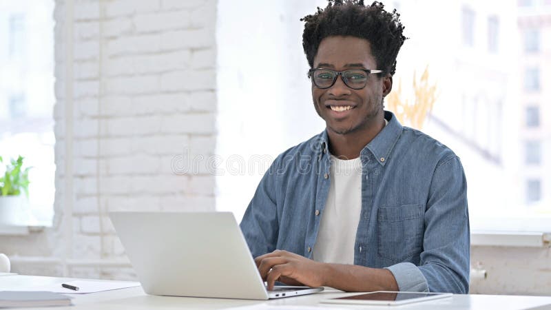 Young African Man Working and Smiling at Camera Stock Image - Image of ...