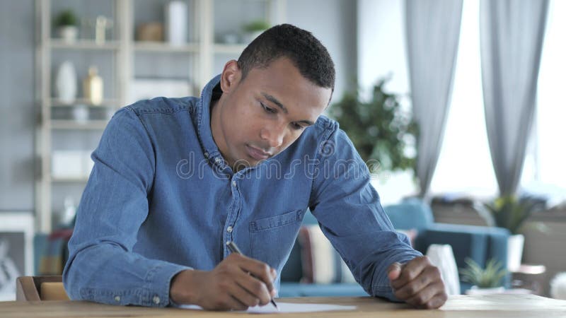 Young African Man Writing on Documents in Office, Paperwork Stock Image ...