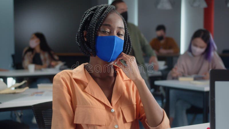A Young African Professor is Sitting in a Blue Protective Mask with Her ...