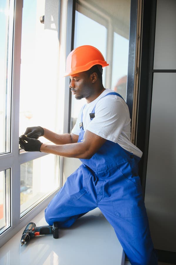 Young African Repairman in Overalls Installing Window Stock Photo ...