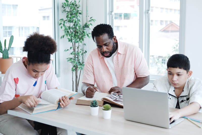 Young African Teacher or Tutor is Reading a Book and Teaching for ...