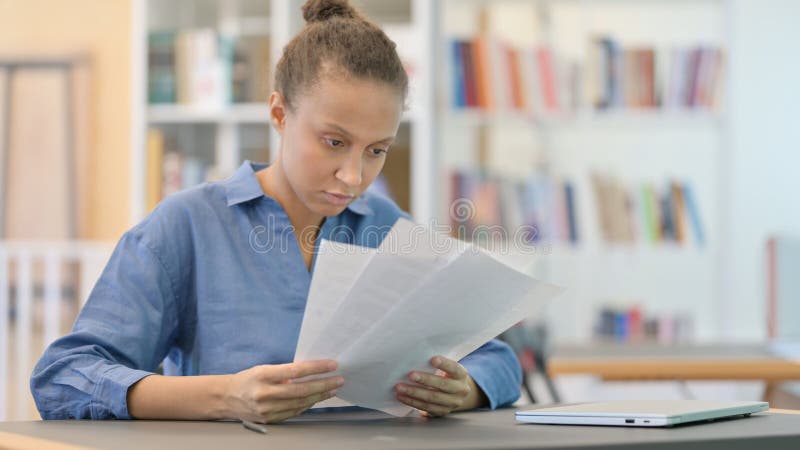 Young African Woman Reading Documents in Library Stock Photo - Image of ...