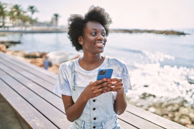 Young African Woman Using Smartphone by the Sea Stock Image - Image of ...
