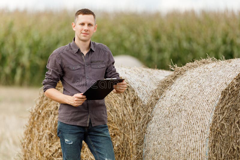 Young Agronomist Holds a Paper Chart in His Hands and Analyzes the Corn ...