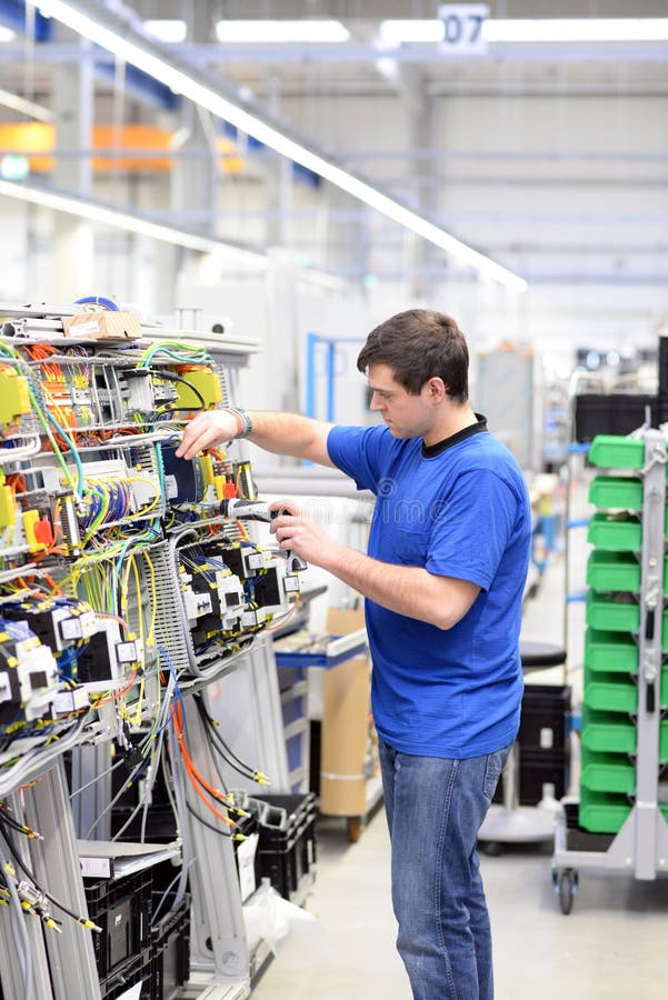 Young Apprentice Assembles Components and Cables in a Factory in a ...