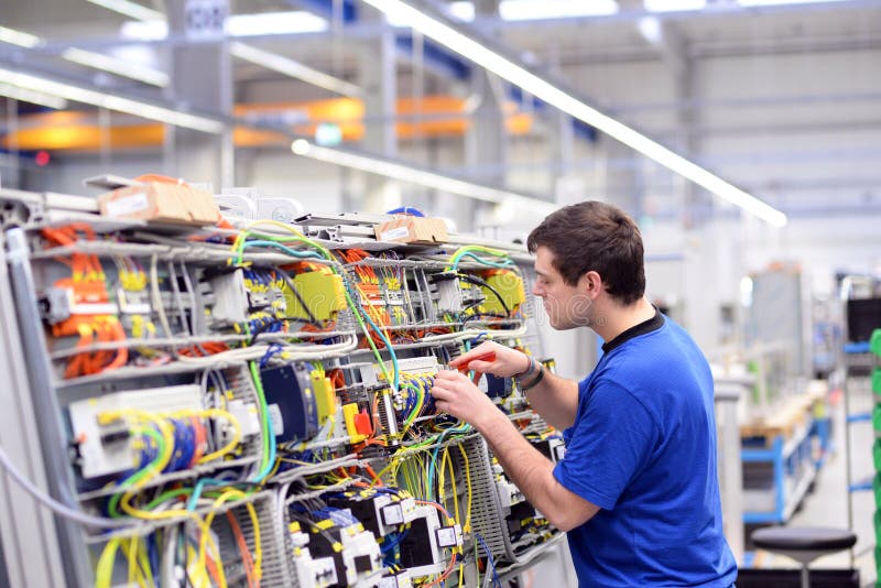 Young Apprentice Assembles Components and Cables in a Factory in a ...