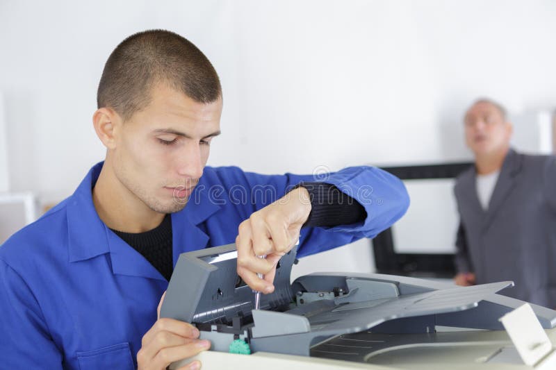 Young Apprentice Man Fixing Photocopier Stock Photo - Image of yellow ...