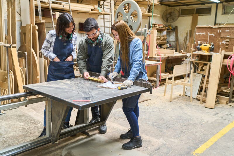 Young Apprentices Collaborating in a Busy Lumberyard Workshop Stock Photo - Image of teamwork ...