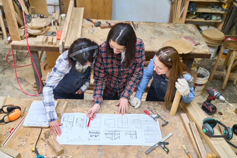 Young Apprentices Learning Woodworking Skills in a Busy Lumberyard ...