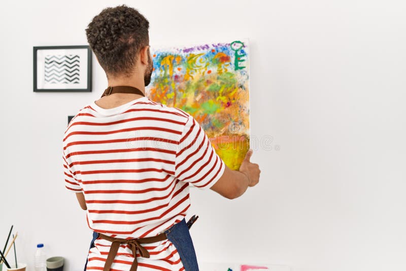 Young Arab Artist Man on Back View Hanging Draw Canvas on Wall at Art ...