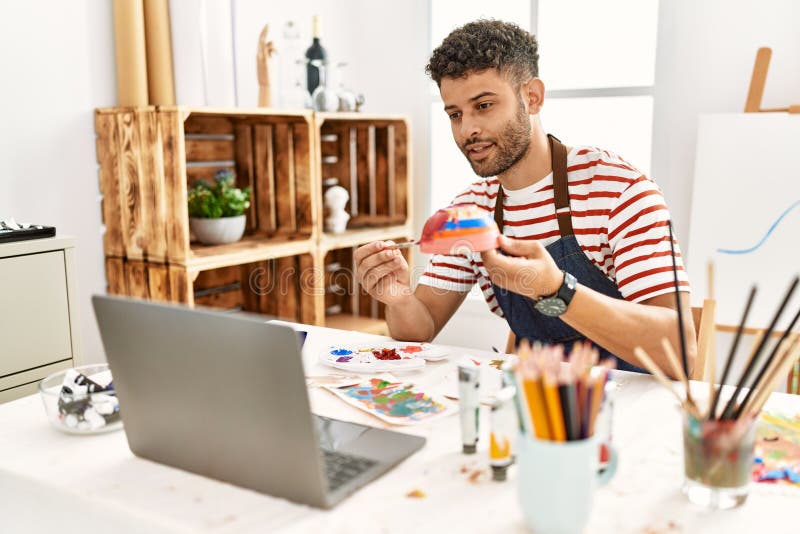 Young Arab Artist Man Using Laptop Drawing Ceramic at Art Studio Stock ...