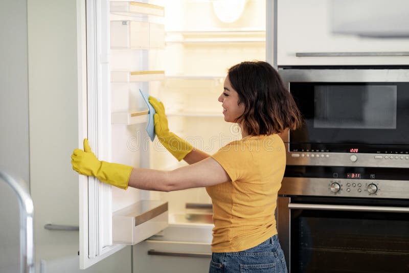 Young Arab Female Using Rag for Cleaning Empty Fridge in Kitchen Stock ...