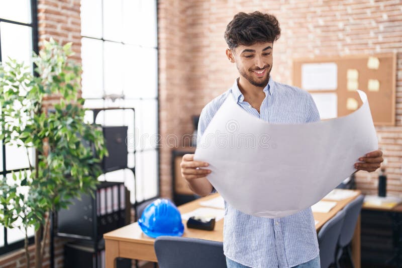 Young Arab Man Architect Reading Blueprints at Office Stock Photo ...