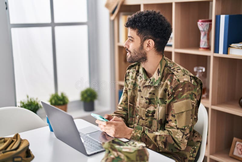 Young Arab Man Army Soldier Using Laptop Using Smartphone at Home Stock ...